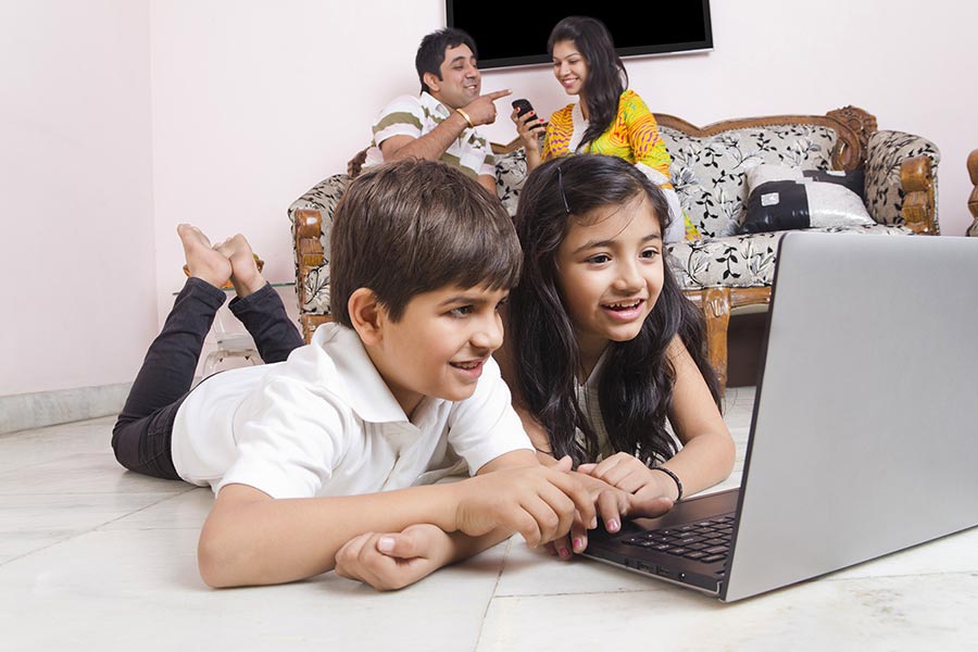 Happy Two-kids Brother And sister using-laptop with Parents on ...