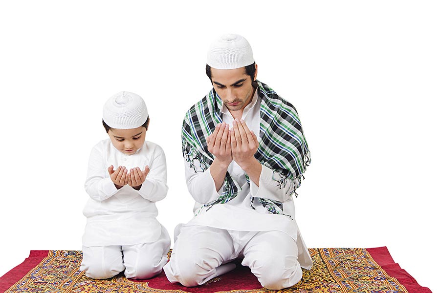 Muslim father and son in-traditional dress praying together at-home ...