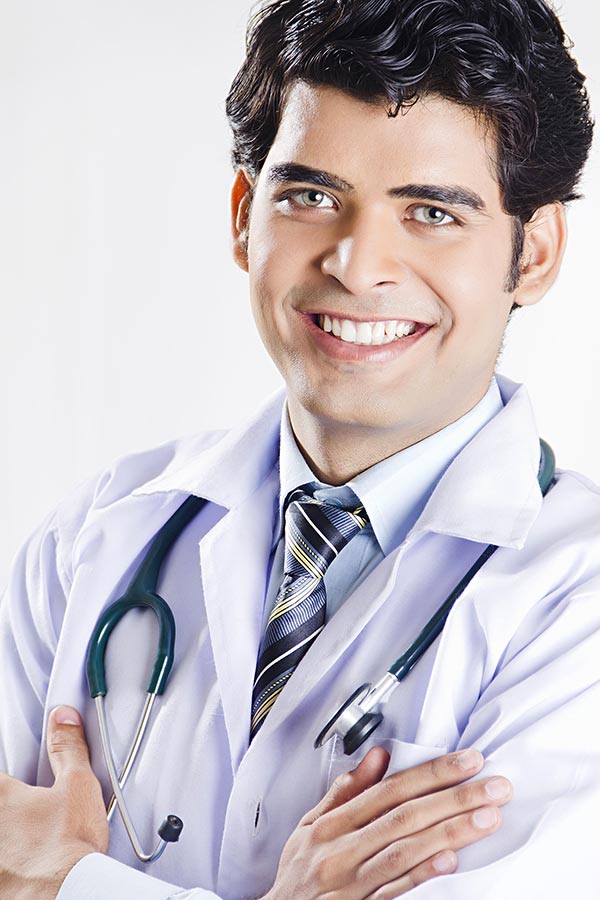 Smiling medical doctor man with stethoscope standing with arms-crossed ...