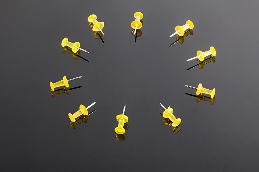 Circle of Yellow push pins isolated on Black Background