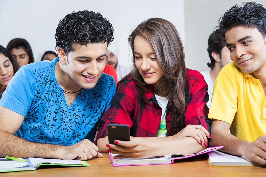 Indian College Friends Students Reading SMS Mobile Phone Classroom