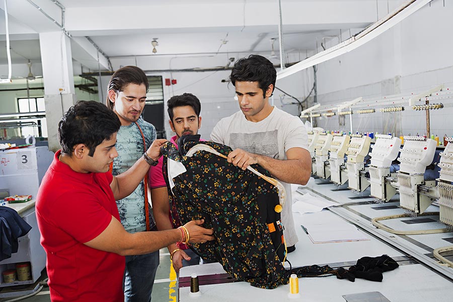Four-male Textile Factory Employee Colleagues Checking Clothes Working ...